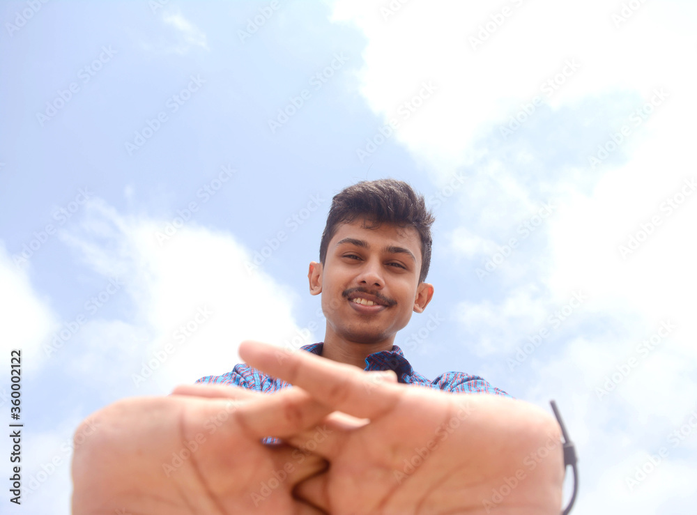 Portrait of attractive hand movements of teen student on sky background ...