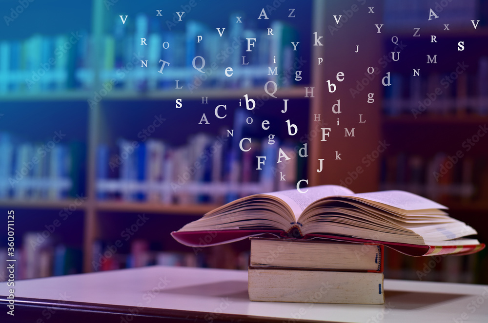 Open book on the table and English alphabet Floating above the book in ...