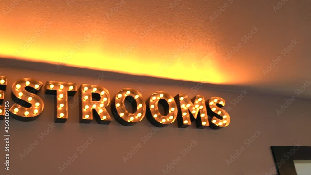 This panning video shows a classic, lighted "restrooms" sign. Stock 비디오 ...