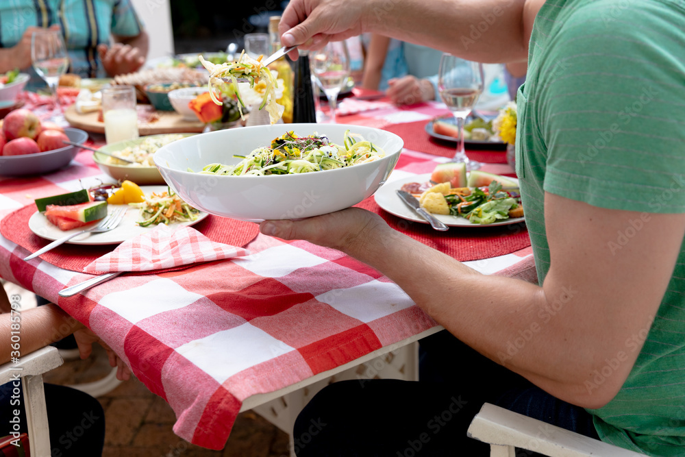 Caucasian family sitting at table during a family lunch in the garden ...