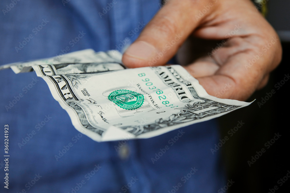 Foto de Young men with one dollar bill in his hand, pay with us note do ...