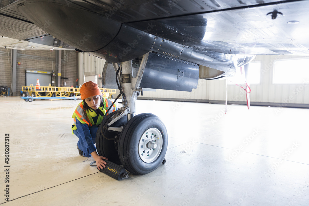 Female ground crew worker inspecting airplane landing gear Stock Photo ...