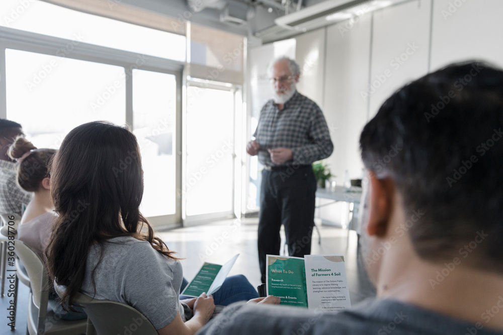 Speaker talking to audience with environmental brochures Stock Photo ...