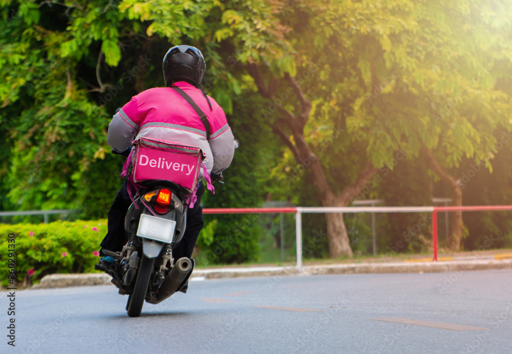 Foto de The delivery staff of the pink form uniform is driving the ...
