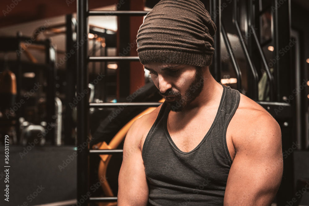 Muscular tired bodybuilder guy showing his muscular body taking a break ...