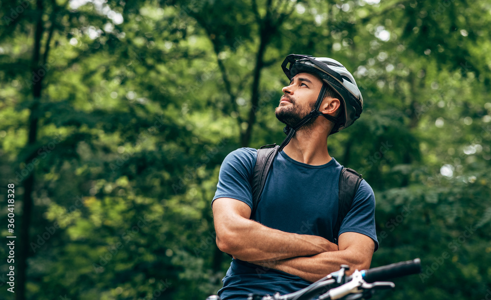 Horizontal outdoor image of handsome cyclist man resting after riding ...