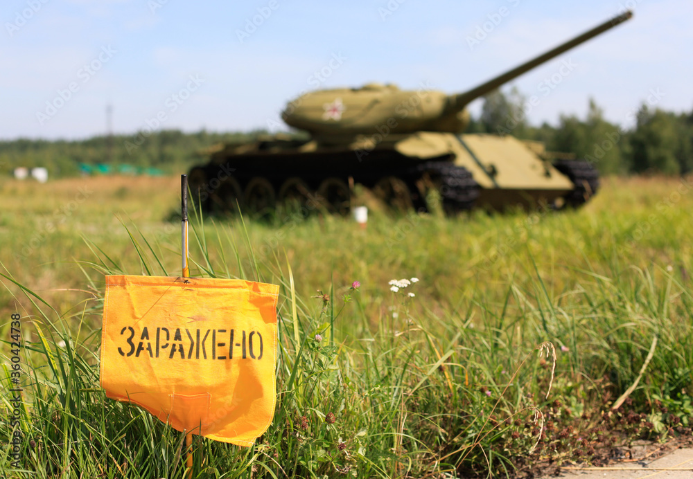 Beautiful day shot of a green grass field with a Yellow warning sign ...