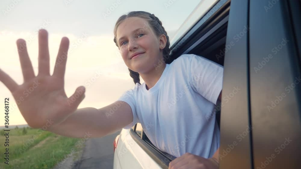 happy girl kid child leaned out of a car window lifestyle waving hand ...