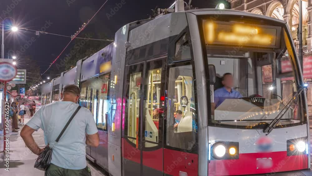 Old tram comes on a stop with the Vienna Opera House Behind timelapse ...