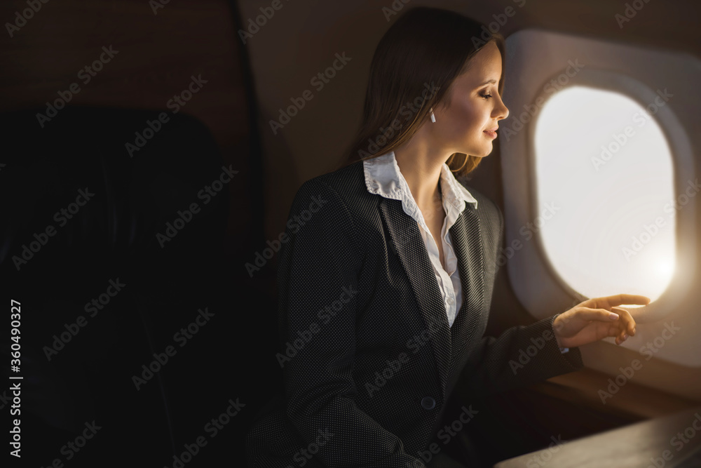 Attractive woman in private jet ภาพถ่ายสต็อก | Adobe Stock