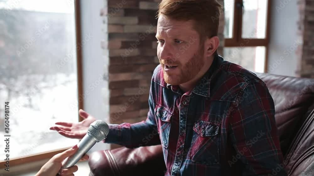 Not happy young man giving interview to a woman journalist with ...
