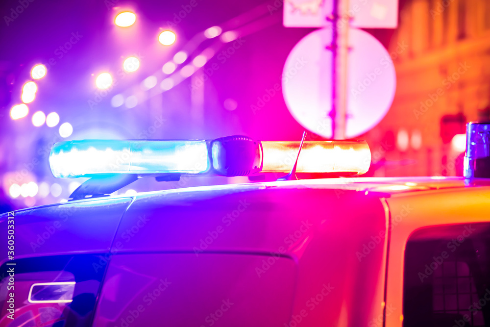 Police car in action with blinking light and siren signal at night in ...