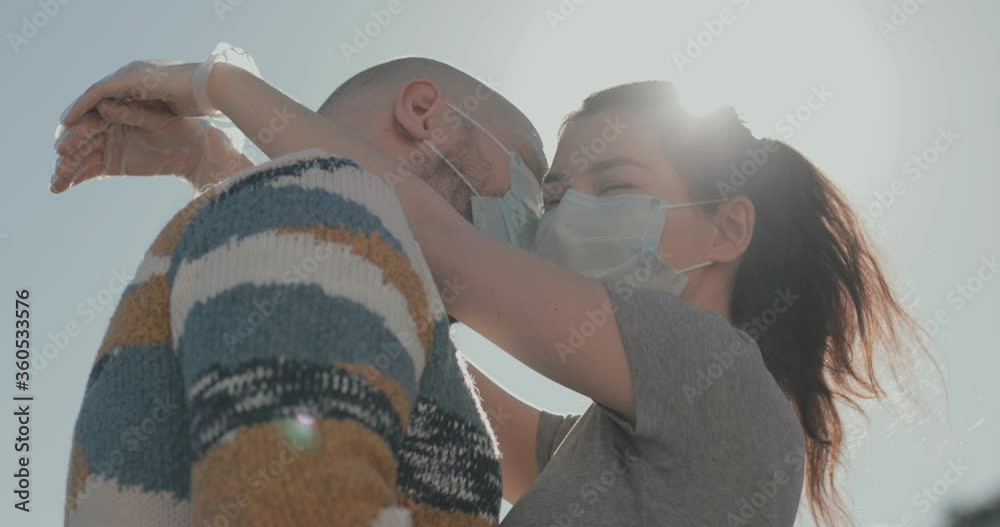 Couple kiss through a mask outside in the sun, end of quarantine Stock ...