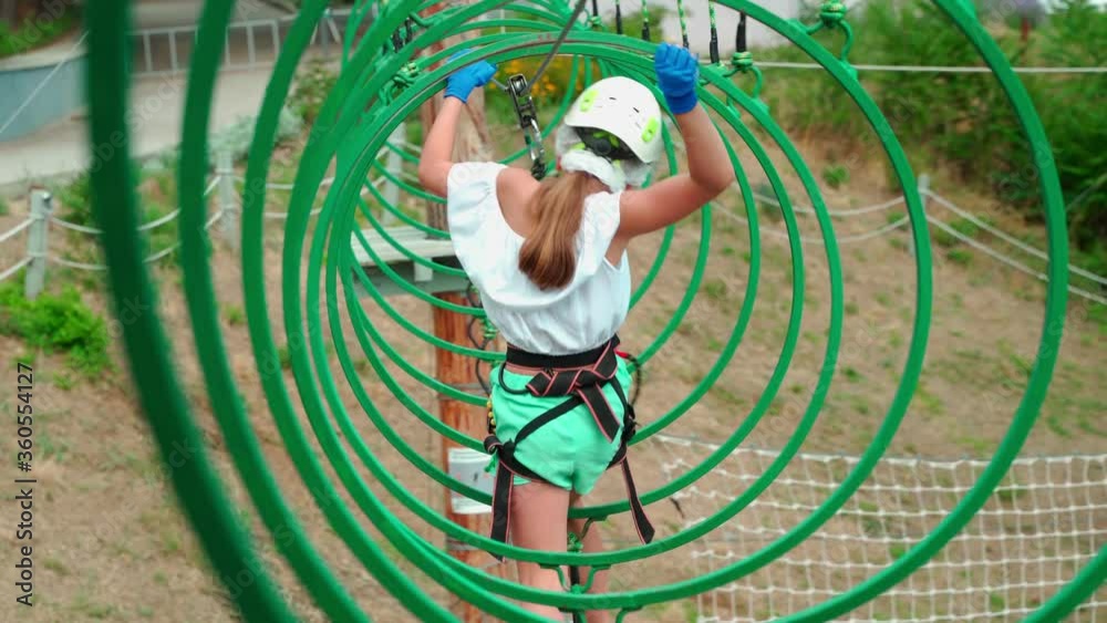 Children in the rope park. Little girls sisters run an obstacle course ...