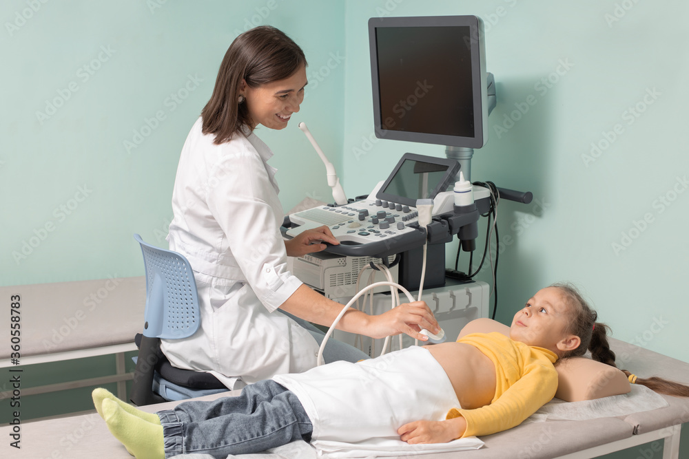 Doctor making abdominal ultrasound for child girl using scanner machine ...