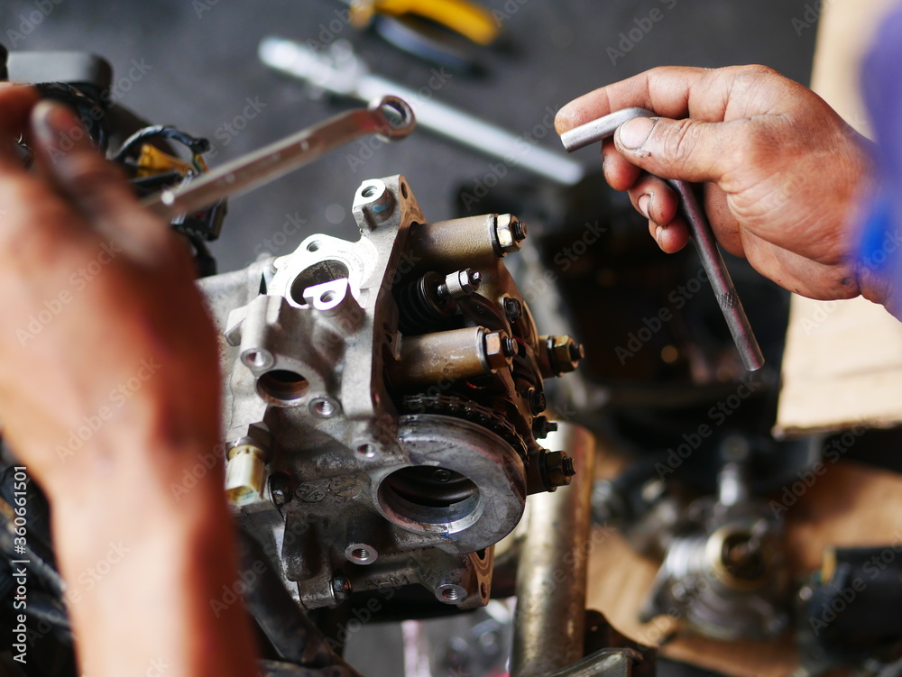 Mechanic working on motorcycle engine in workshop. Stock Photo | Adobe ...