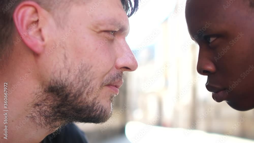 Close portrait of angry men, interracial portrait. Side view of a white ...