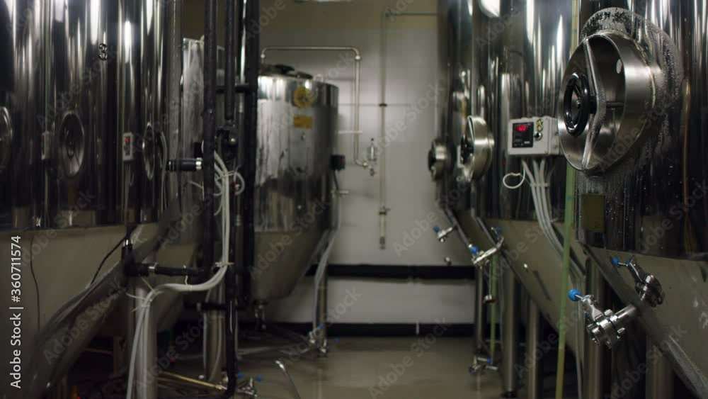 An empty factory room with metal tanks at the end of the working day. A ...