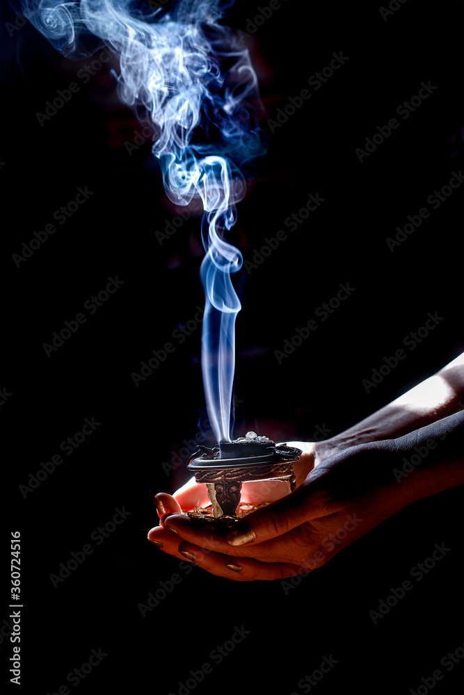 incense in a woman hand, incense smoke on a black background. Stock ...