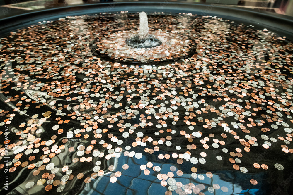 Coins in fountain. Copper and silver coins thrown in to the bottom as ...
