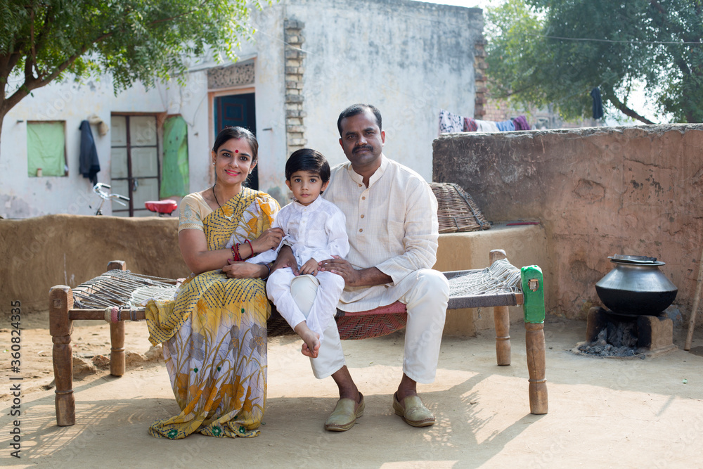 Poster Happy rural family sitting on traditional bed at villages – Wall ...