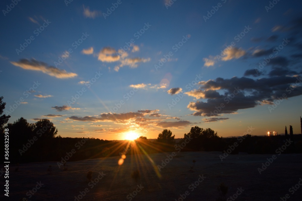 Beautiful scenery of the sunset sky with bright sun rays over a ...