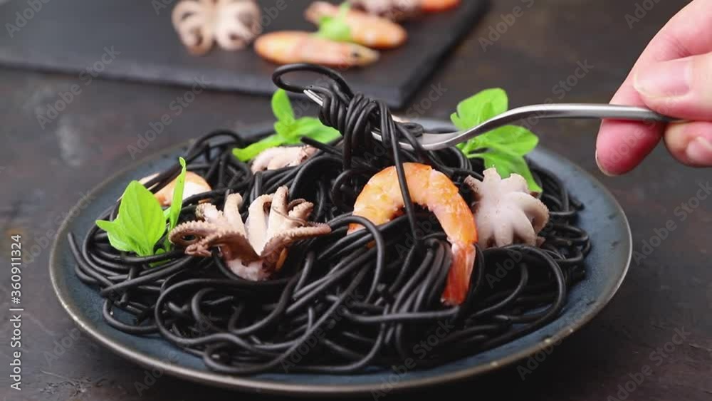 black cuttlefish ink pasta with shrimps or prawns, small octopuses and ...