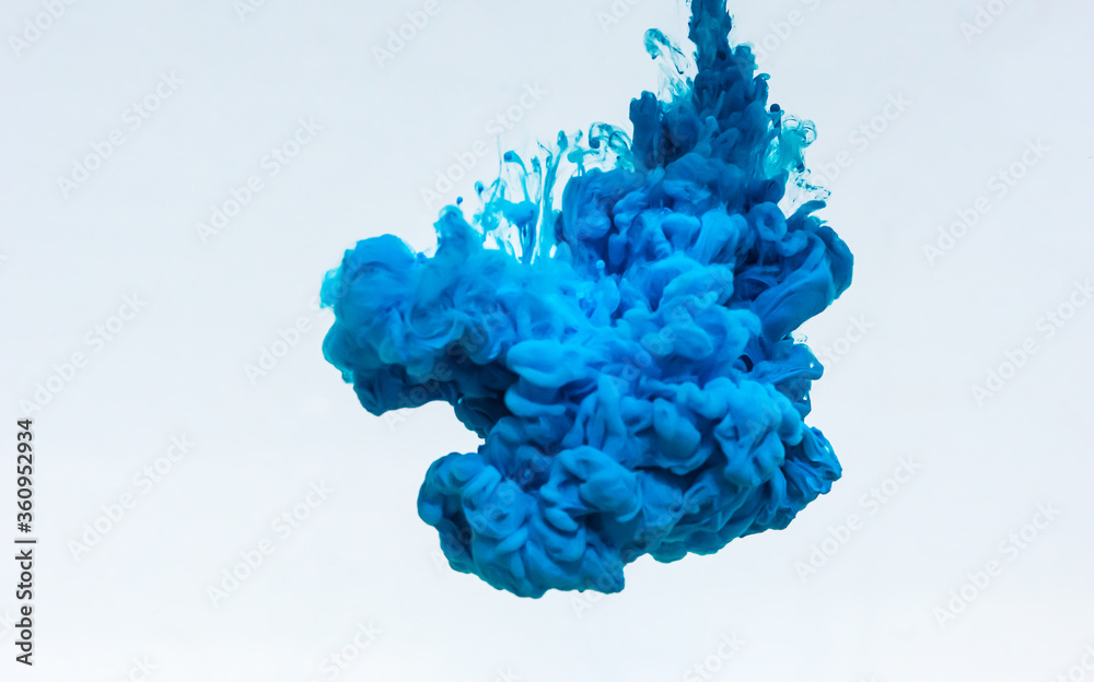 Squeezing the blue paint into the water. Blue ink in water isolated on ...