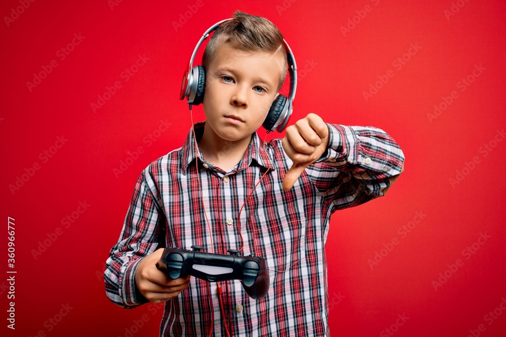 Young little caucasian gamer kid playing video games using gamepad ...