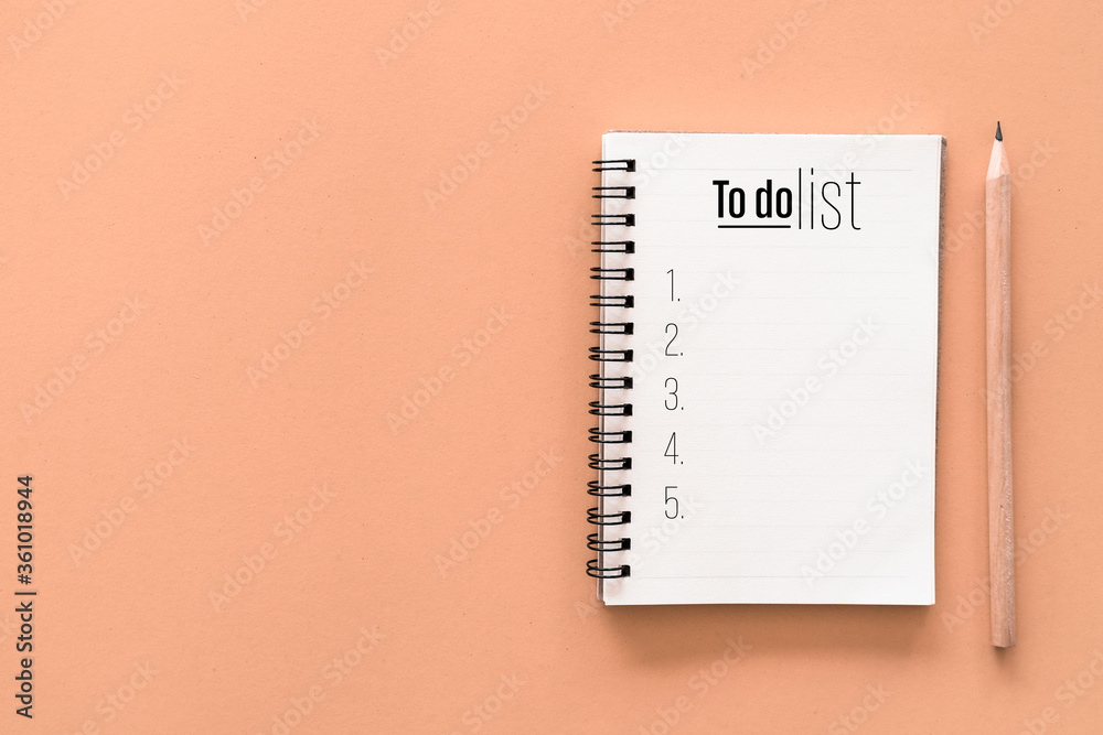 Notebook and pencil with to do list words on pastel color background ...