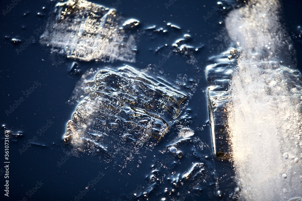 Shiny shards of ice crystals in water. Transparent ice on clear water ...