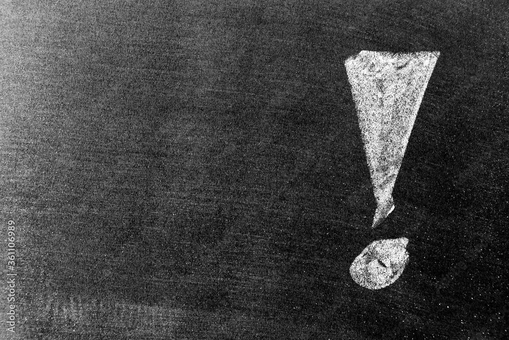 White color chalk hand drawing in exclamation mark with blank space ...