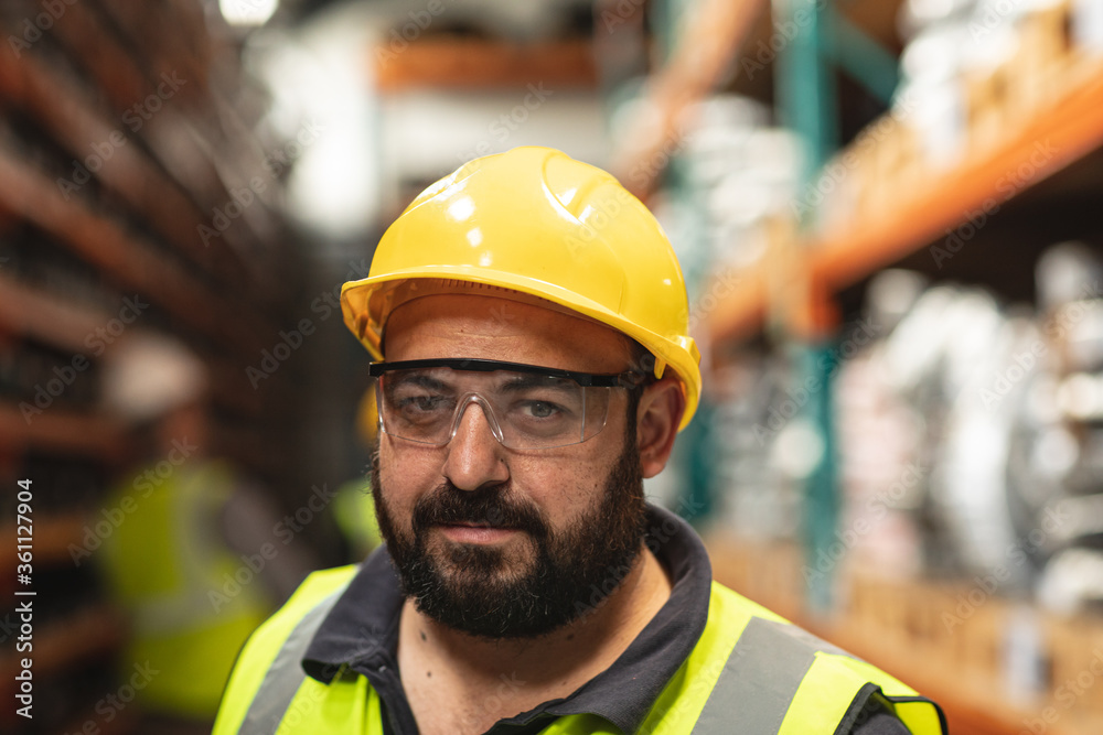 Portrait of a male factory worker wearing a safety helmet and glasses ...