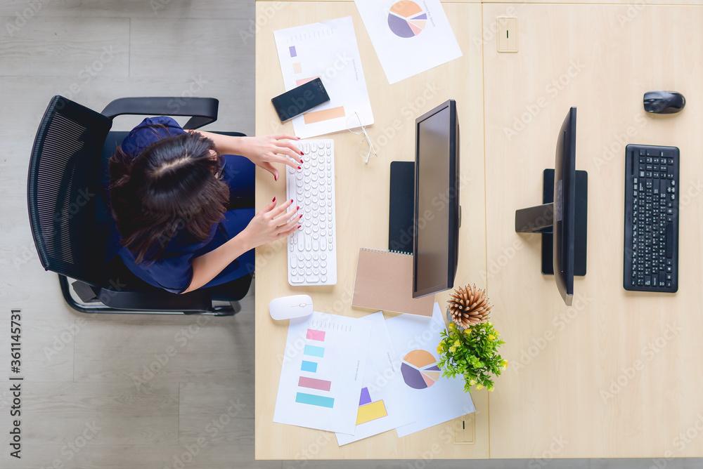 Top view of the desk in office, an Asian woman is sitting in front of ...