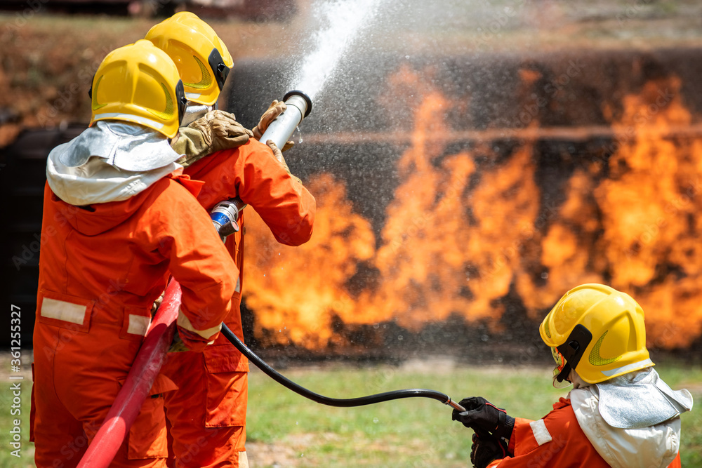 Group of firefighter in fire suit using water and chemical foam from ...