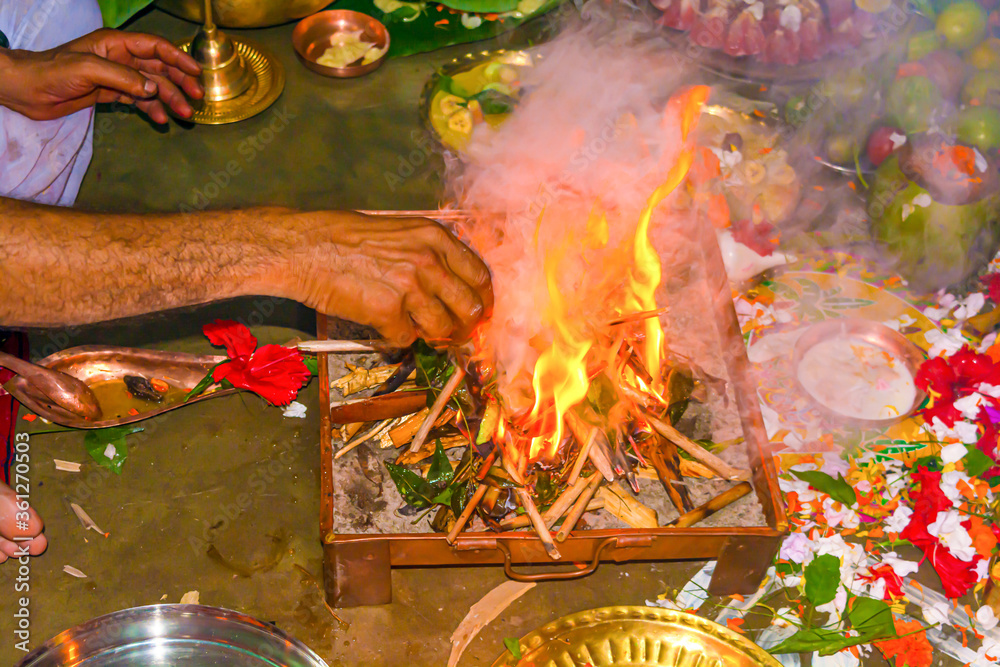 Hand of a hindu brahmin priest worshiping hindu God by performing yajna ...