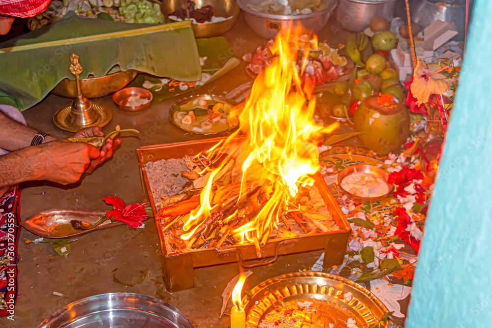 Hand of a hindu brahmin priest worshiping hindu God by performing yajna ...