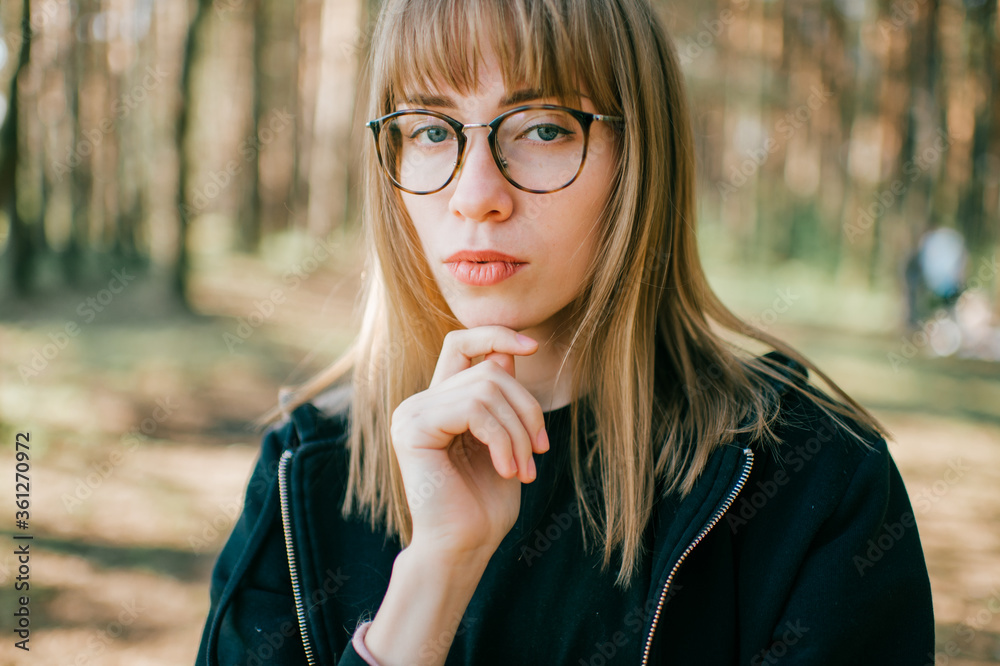 Portrait of beautiful young girl with short fair hair, blue eyes, black ...