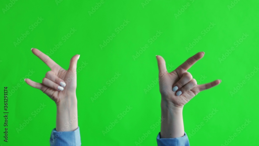 Foto de Sign of the horns with fingers on green screen. Simbol of heavy ...