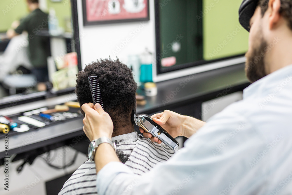 Professional barber makes new haircut with electric shaving machine ...