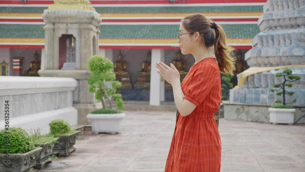 Side view of asian woman bowing and doing Asian greeting at buddhist ...