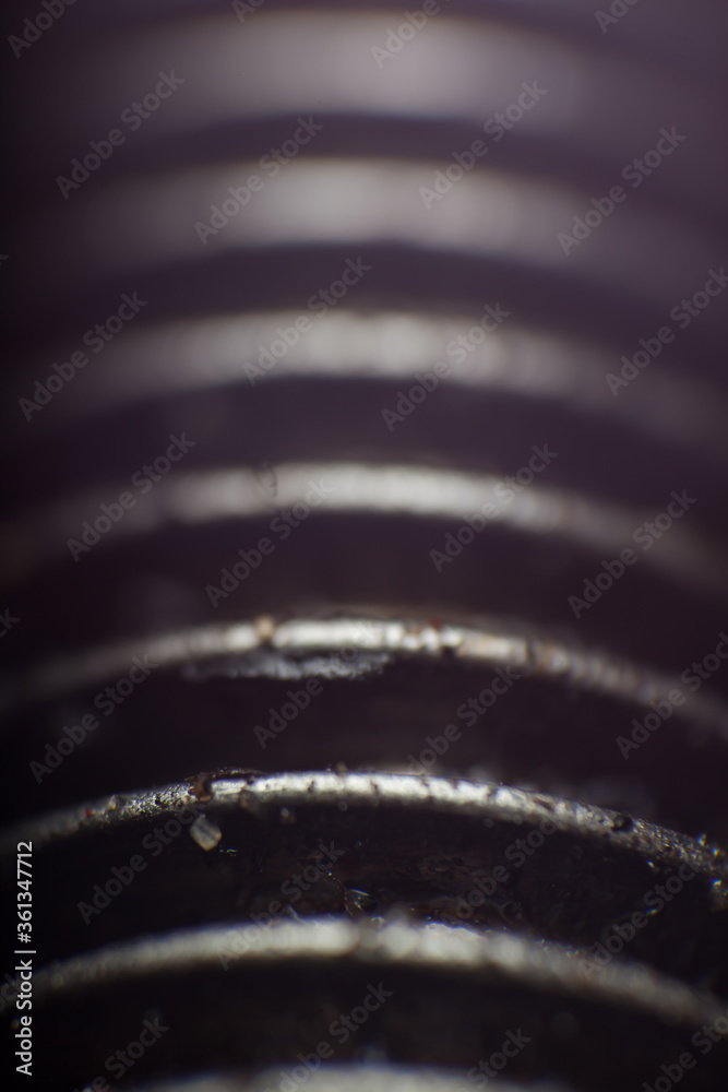 A close-up of a thread of a bolt on a black background as a design ...