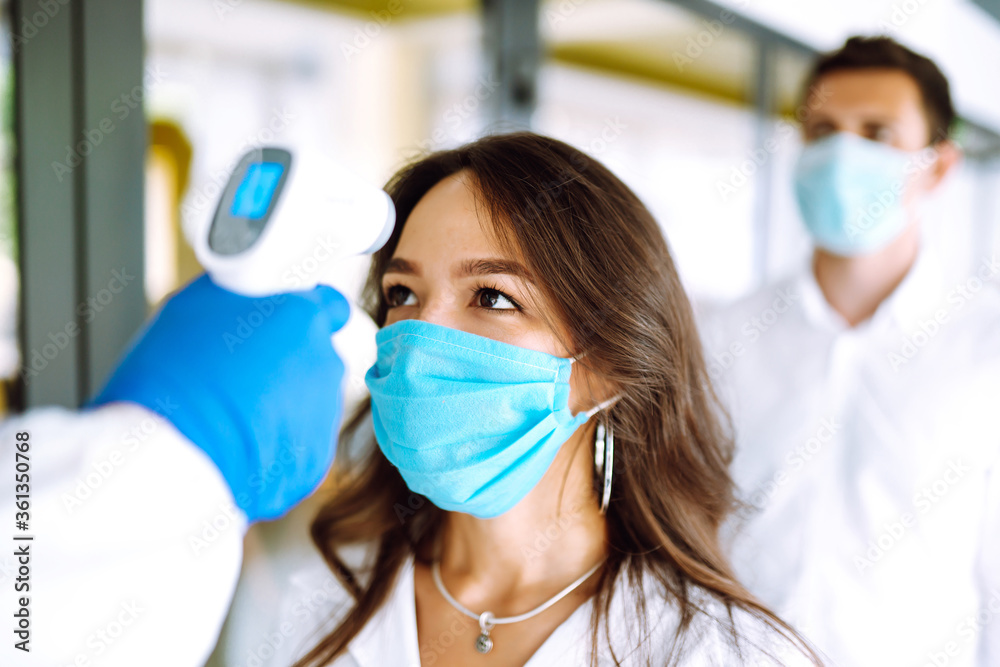 Hand in glove holding ir thermometer. Medical office measurement ...