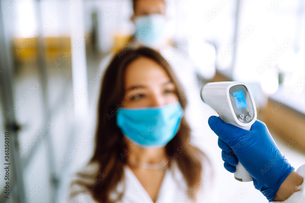 Hand in glove holding ir thermometer. Medical office measurement ...