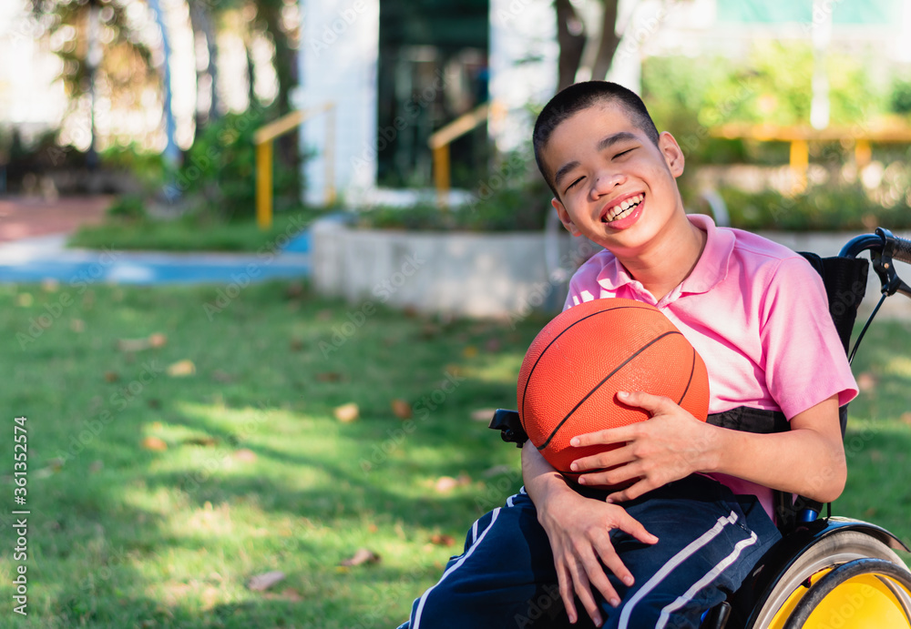 Asian special child on wheelchair is playing basket ball to strengthen ...