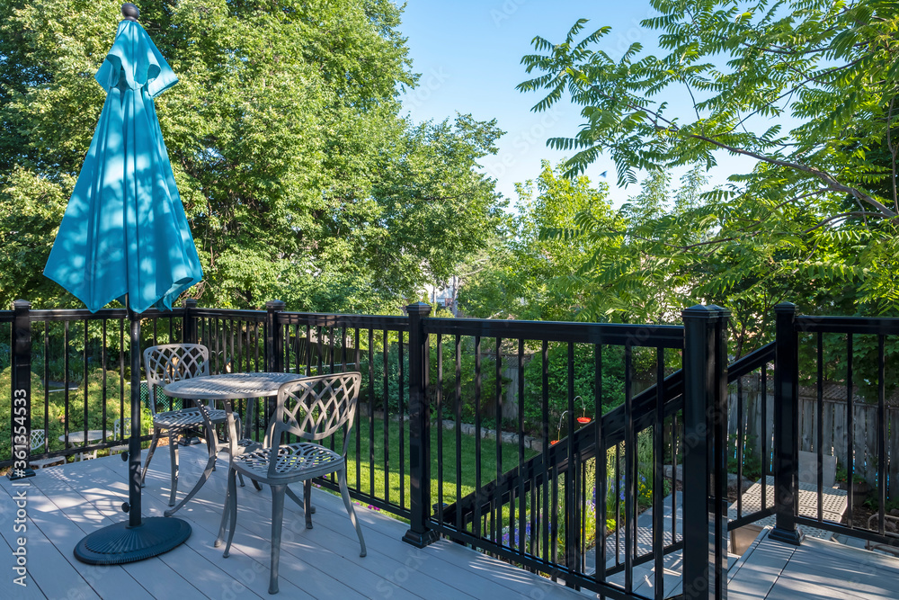 Gray PVC Deck with Black Metal Railing, a Bistro Set and Blue Sun ...