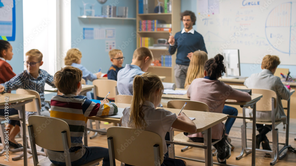 Caring Teacher Explains Lesson to a Classroom Full of Bright Diverse ...