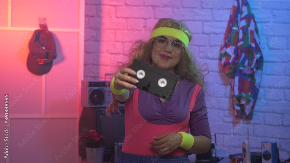 Girl from the 1980 1990 era holding a vintage movie VHS cassette tape ...