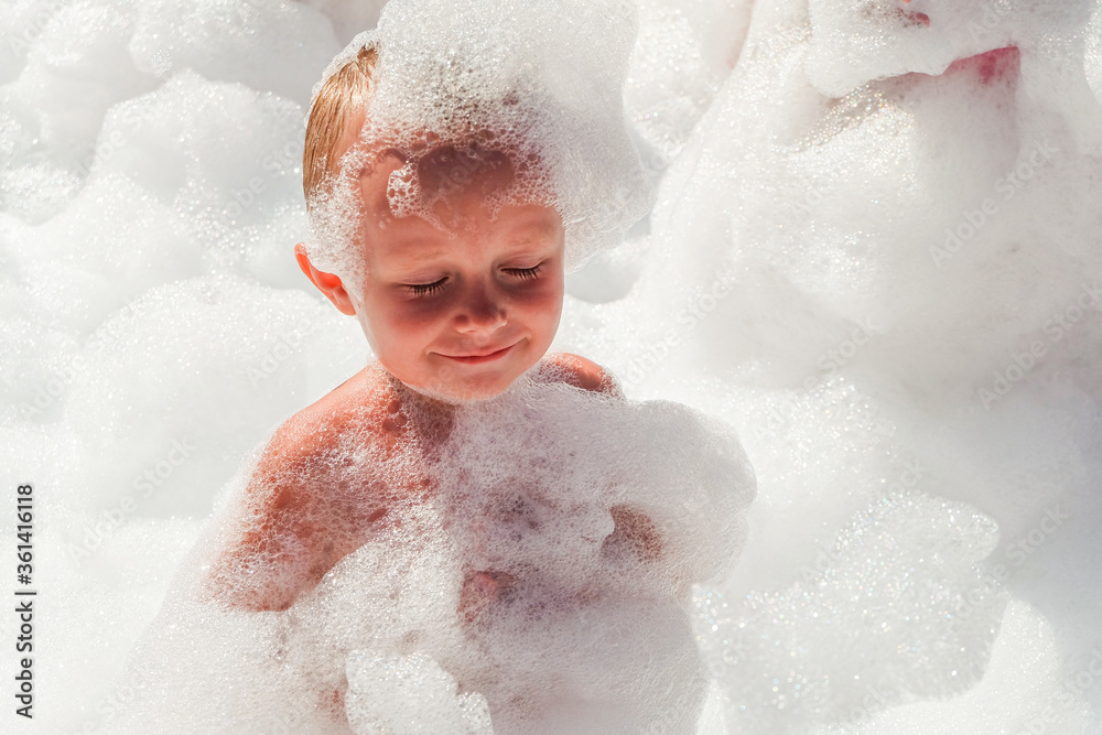 Little boy in airy foam on a dance party floor. Foamy children disco ...