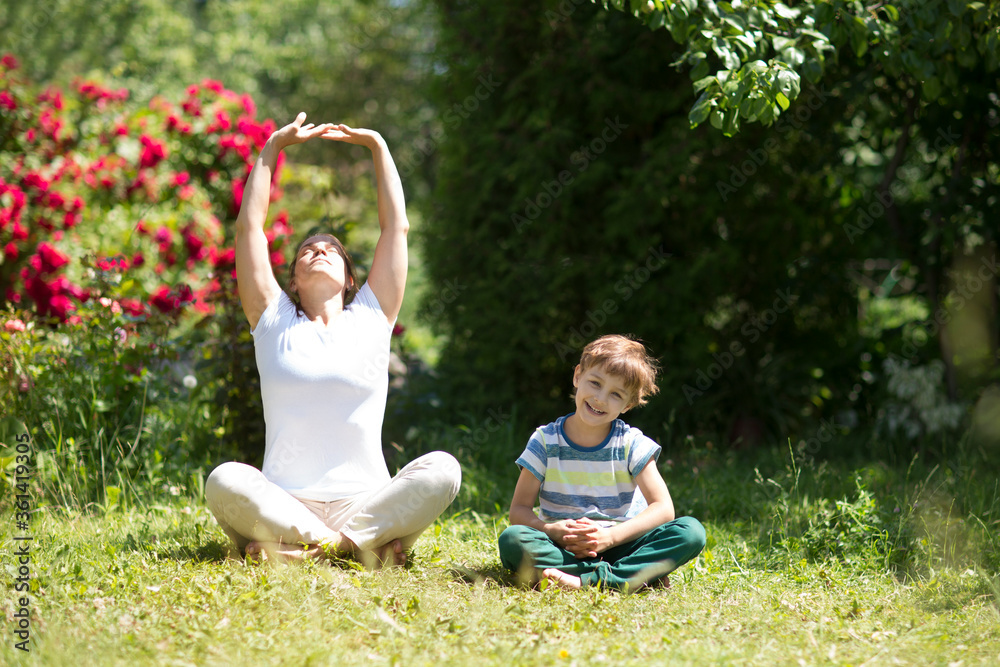 Family mother and son preschool child practice Tai Chi Chuan in a park ...